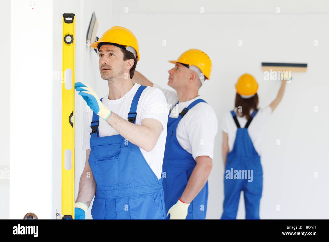 Team of workers align wall at new house Stock Photo - Alamy