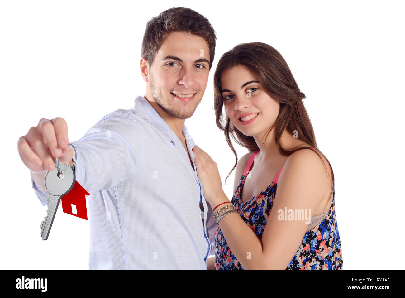 Portrait of a young beautiful couple holding new house keys. Isolated ...