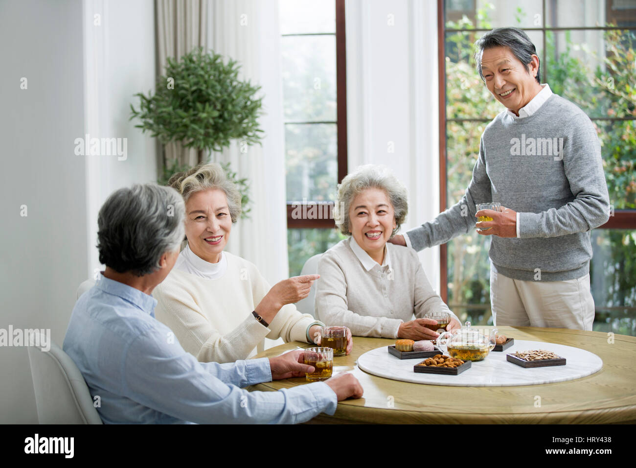 Happy senior friends talking and drinking tea Stock Photo - Alamy