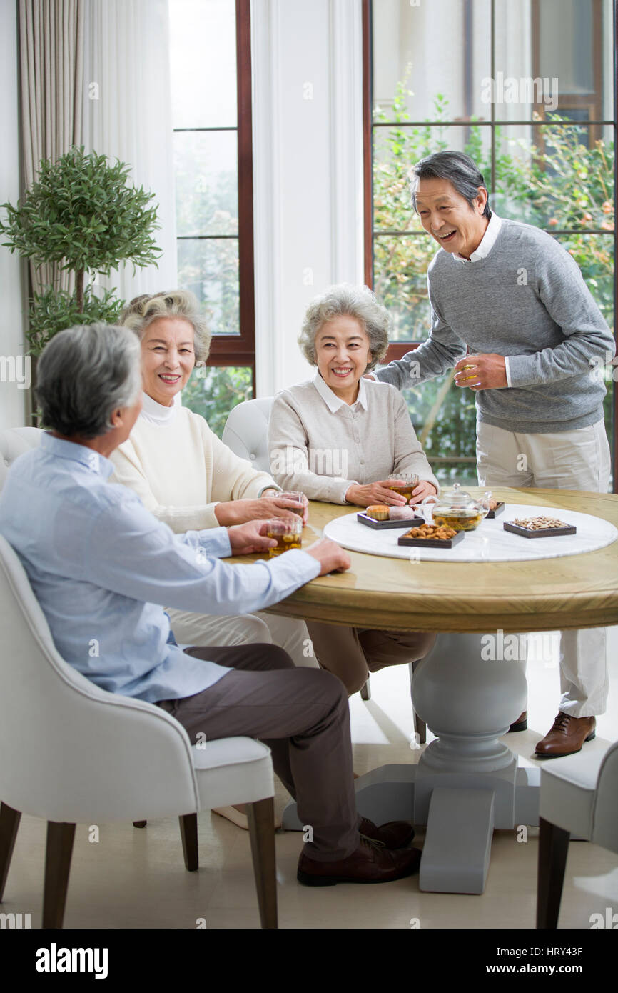 Happy senior friends talking and drinking tea Stock Photo - Alamy