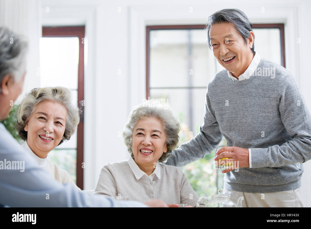 Happy senior friends talking and drinking tea Stock Photo - Alamy