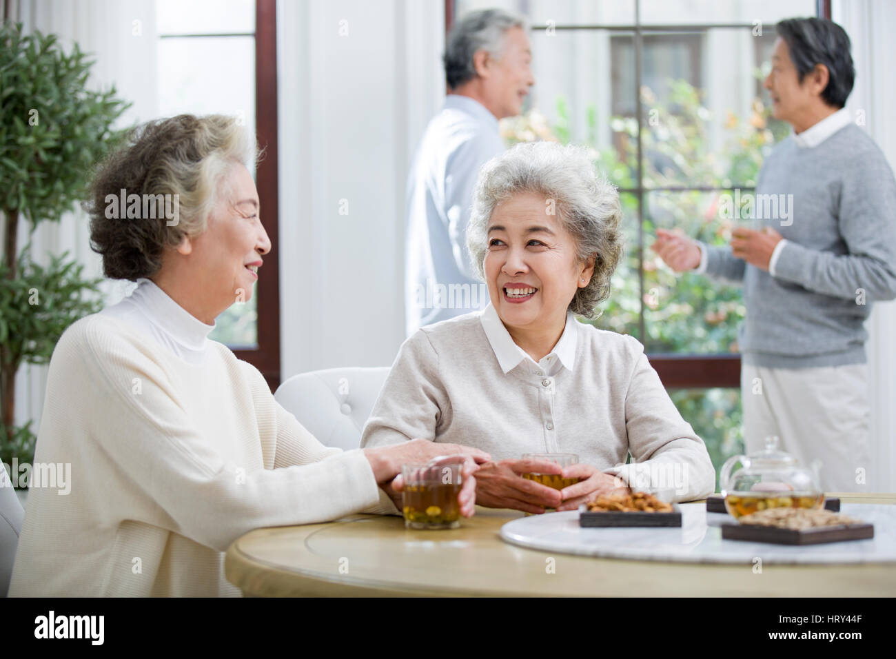 Happy senior friends talking and drinking tea Stock Photo - Alamy