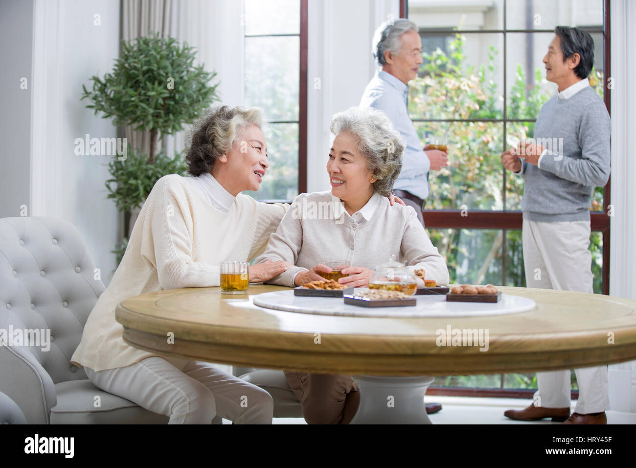 Happy senior friends talking and drinking tea Stock Photo - Alamy