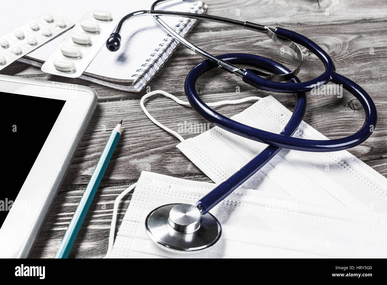 Doctors wooden table with white tablet and stethoscope Stock Photo - Alamy