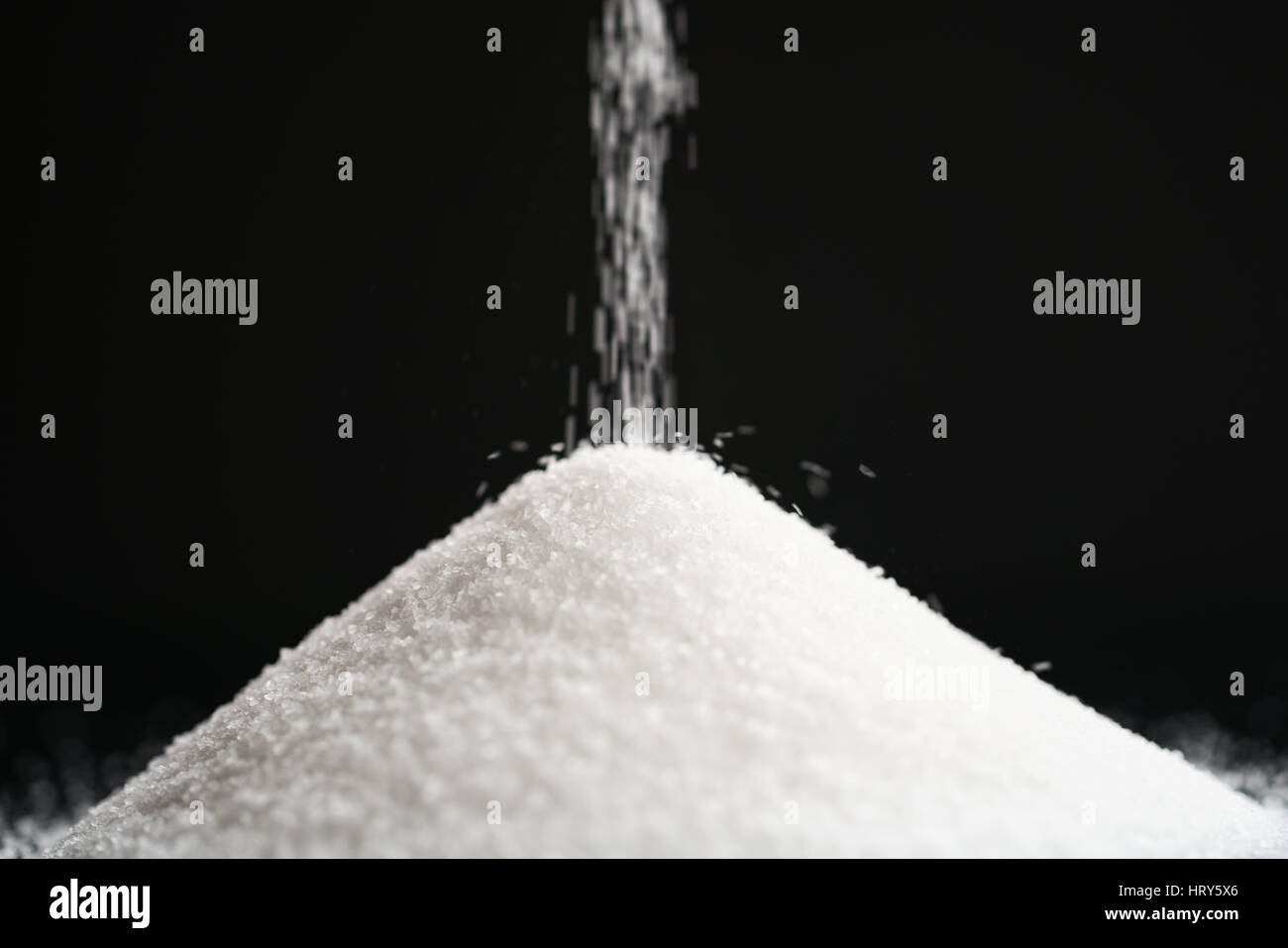 white sugar falling agains black background, shallow focus Stock Photo ...