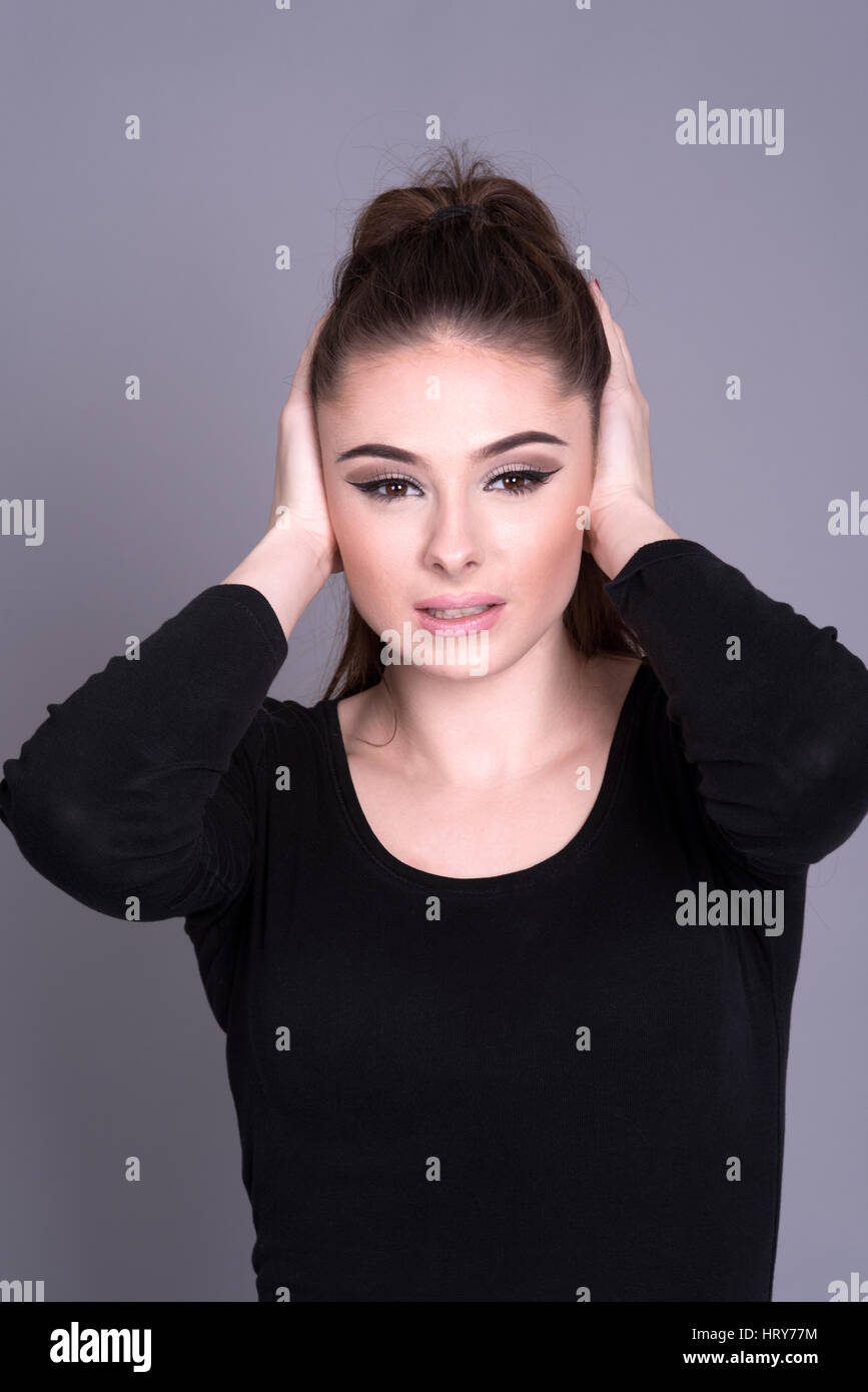 Young woman holding hands over her ears Stock Photo - Alamy