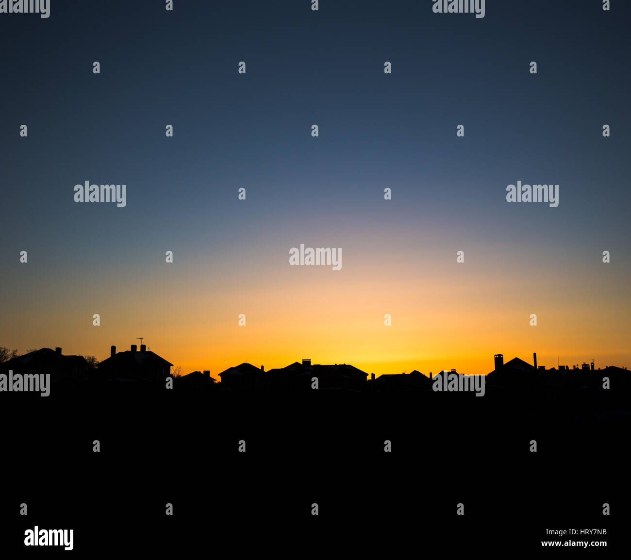 Evening sun setting behind a row of suburban houses Stock Photo - Alamy