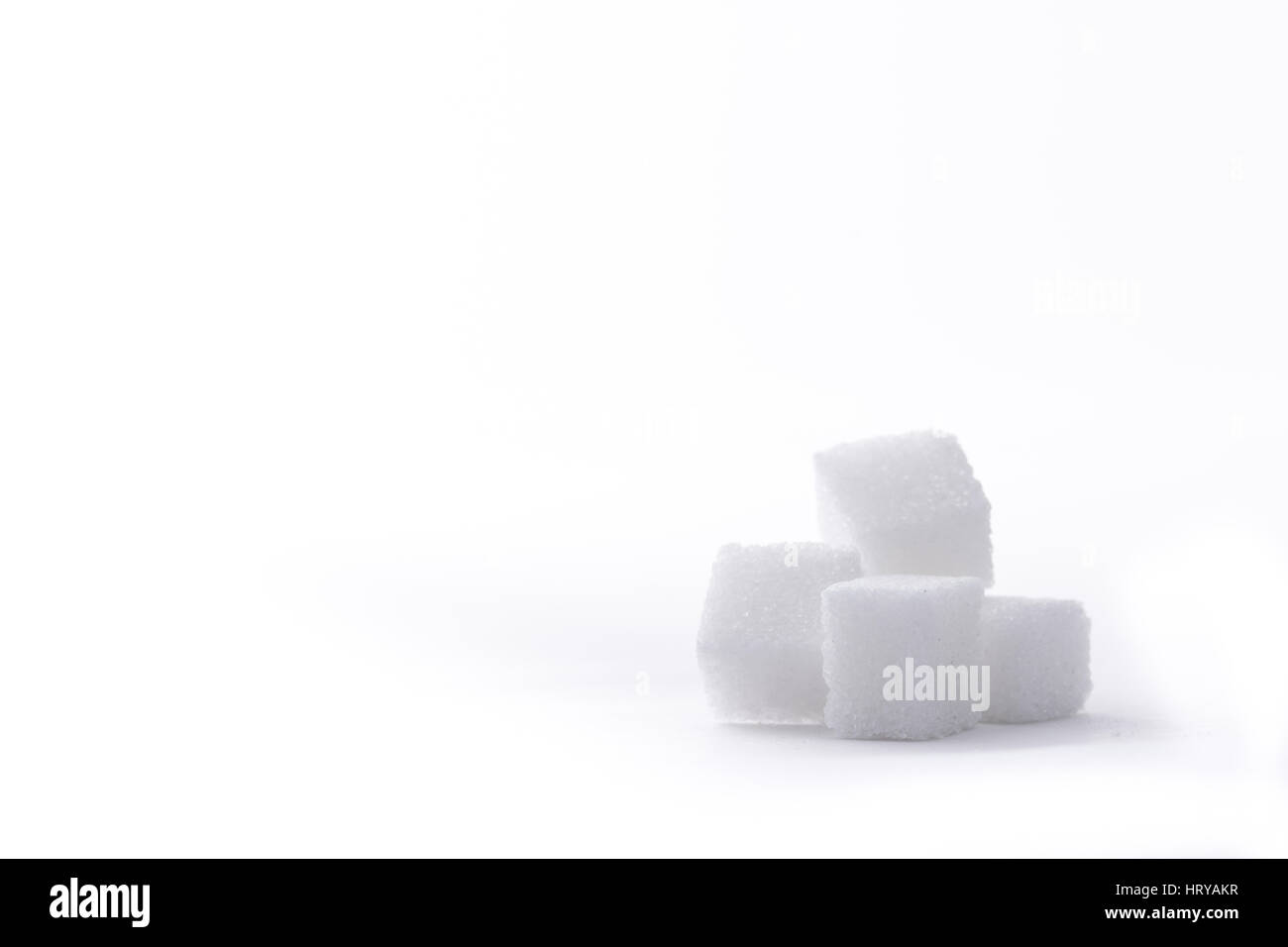 A stack of white sugar cubes, isolated in front of a white background ...