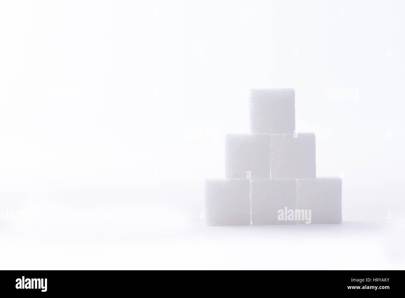 A pyramid made out of sugar cubes, isolated in front of a white ...
