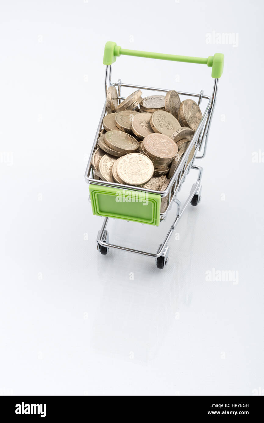 Pound coins in shopping basket / trolley. Representing UK consumer ...