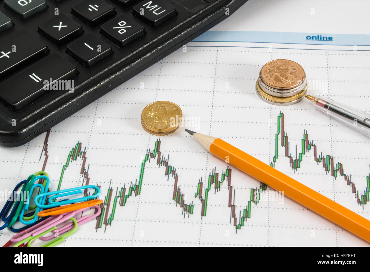 Financial graph on white background with calculator, coins, pens ...