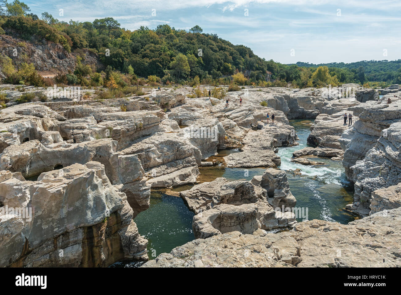 People walking along the bank of the river Ceze at Cascades Du Sautadet ...