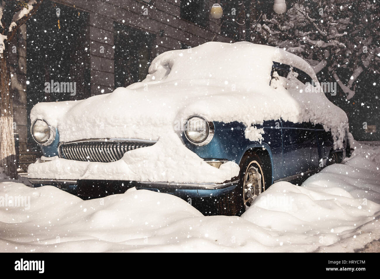 Blue retro car covered with snow parked in an urban street Stock Photo ...