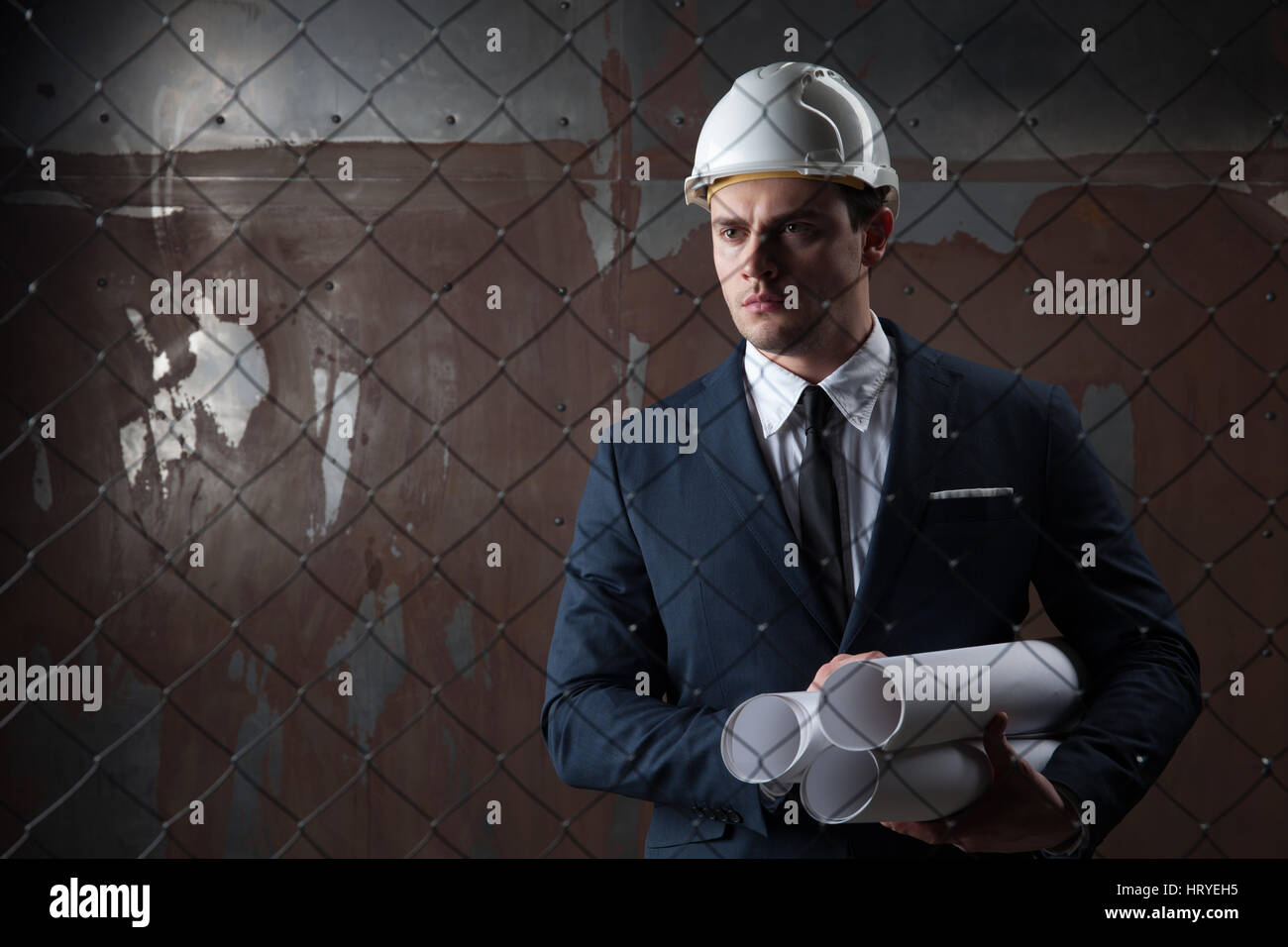 Portrait of a young architect in industrial concept in white helmet and ...