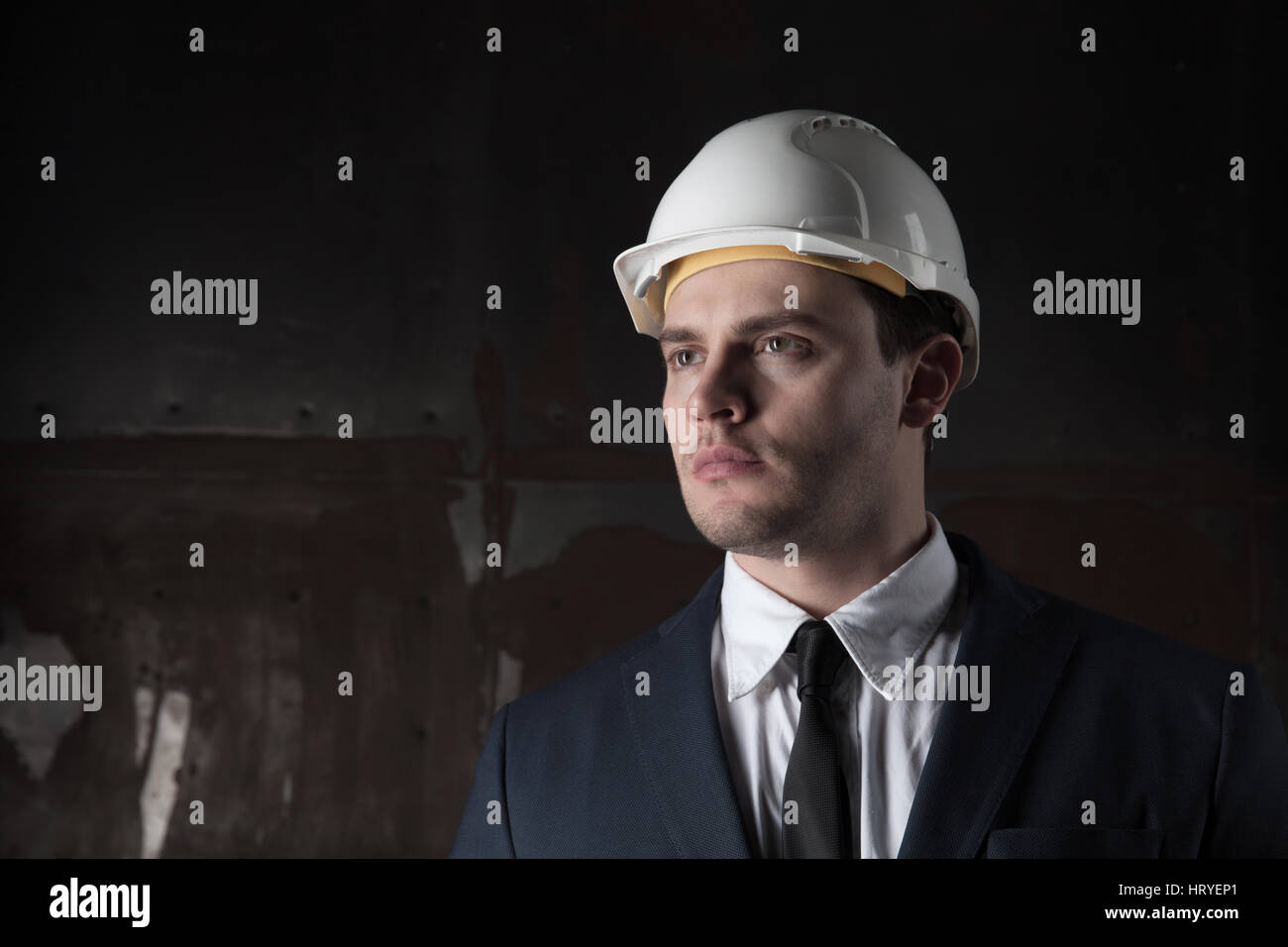 Portrait of a young architect in industrial concept in white helmet and ...