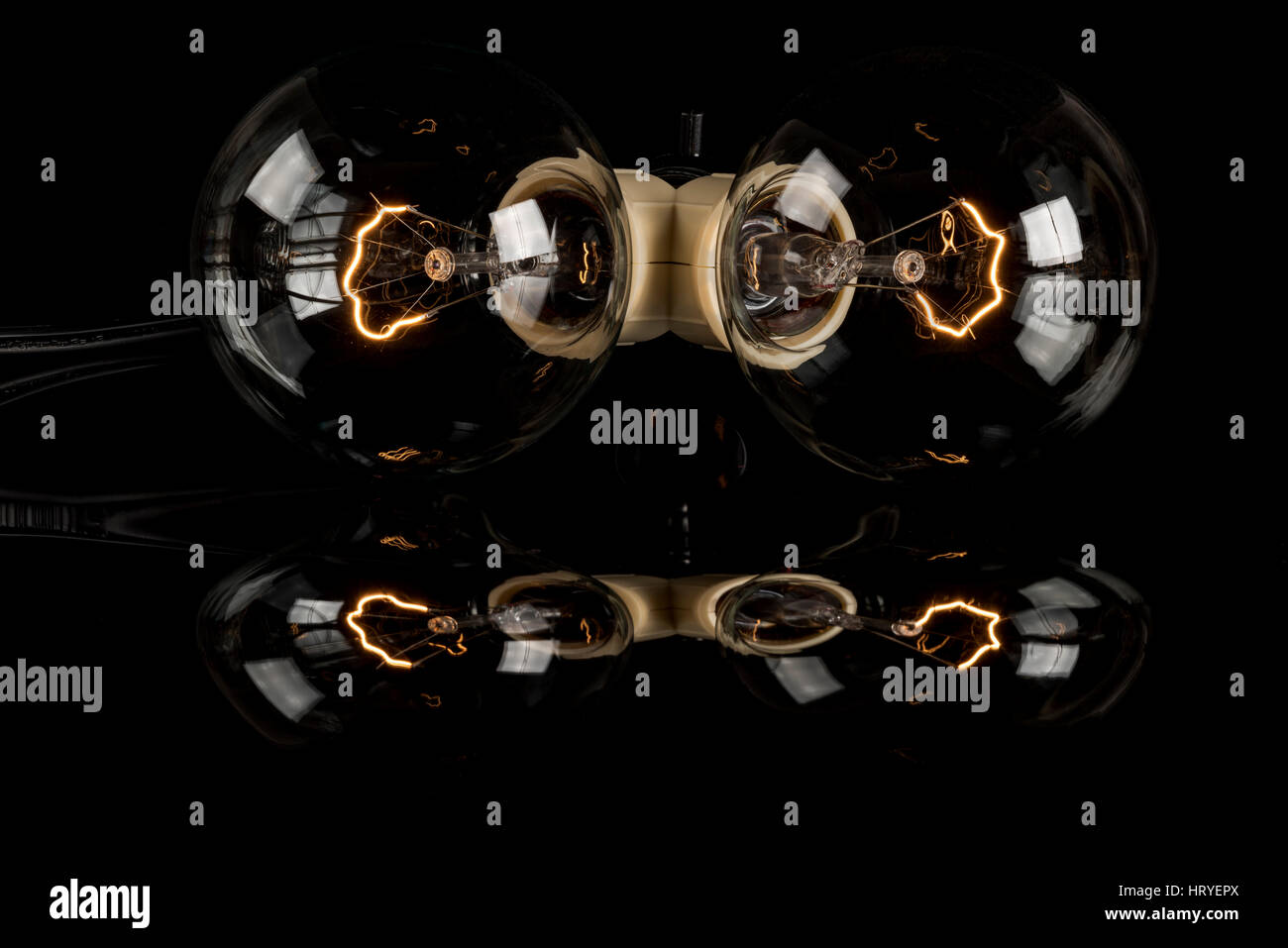 Incandescent light bulbs glowing with a reflection Stock Photo - Alamy