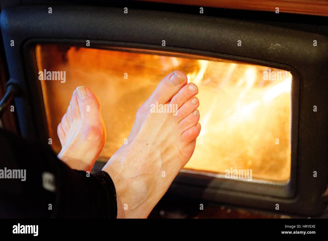 Cold feet warming in front of a blazing fire Stock Photo - Alamy