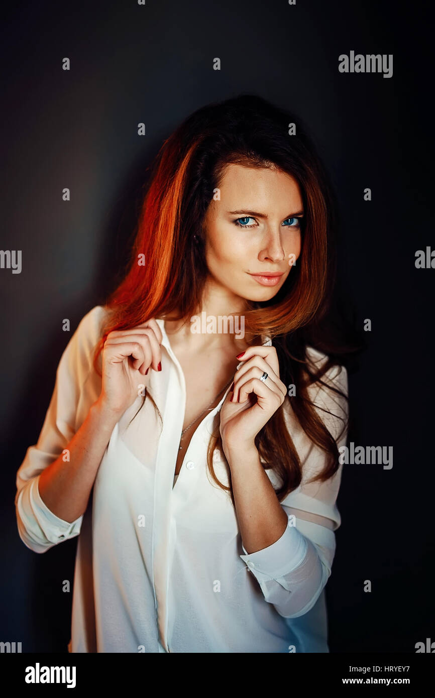 Beautiful girl standing near the dark blue wall in darkness in blue ...