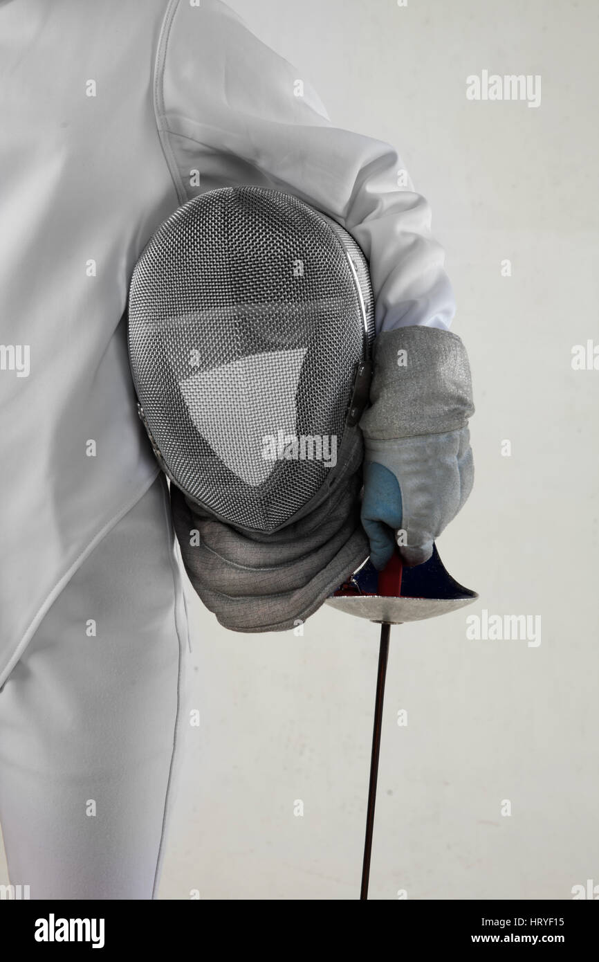 Female fencer hold epee and ferncer mask wearing white fencing costume ...