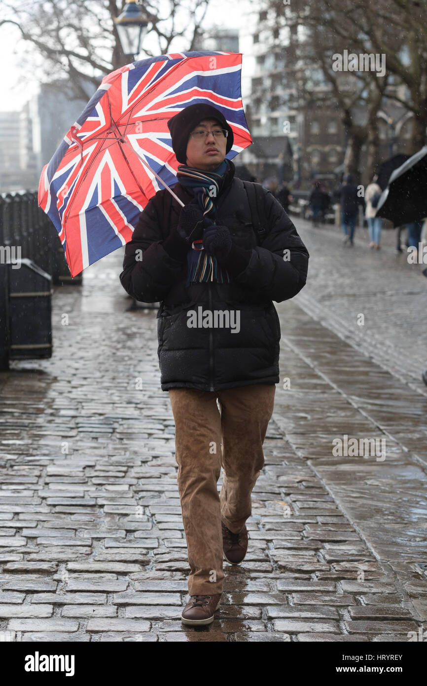London, UK. 5th Mar, 2017. A man with a union jack umbrella is caught ...
