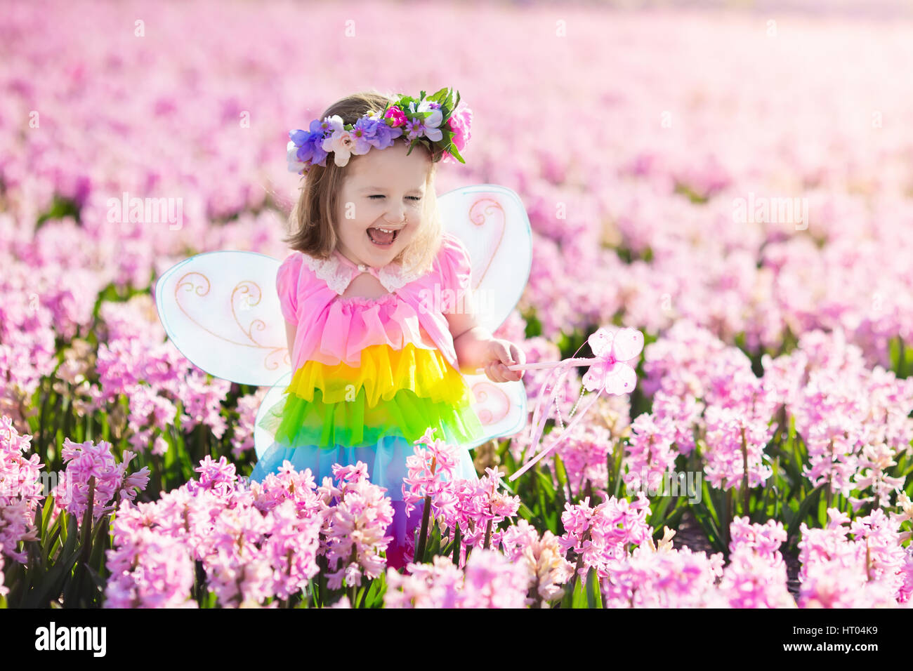 Beautiful girl playing in blooming hyacinth flower field. Kids princess ...