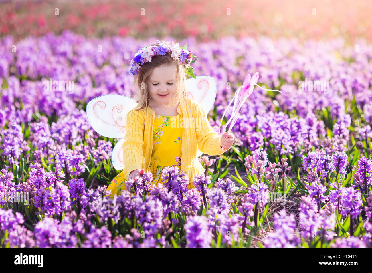 Beautiful girl playing in blooming hyacinth flower field. Kids princess ...