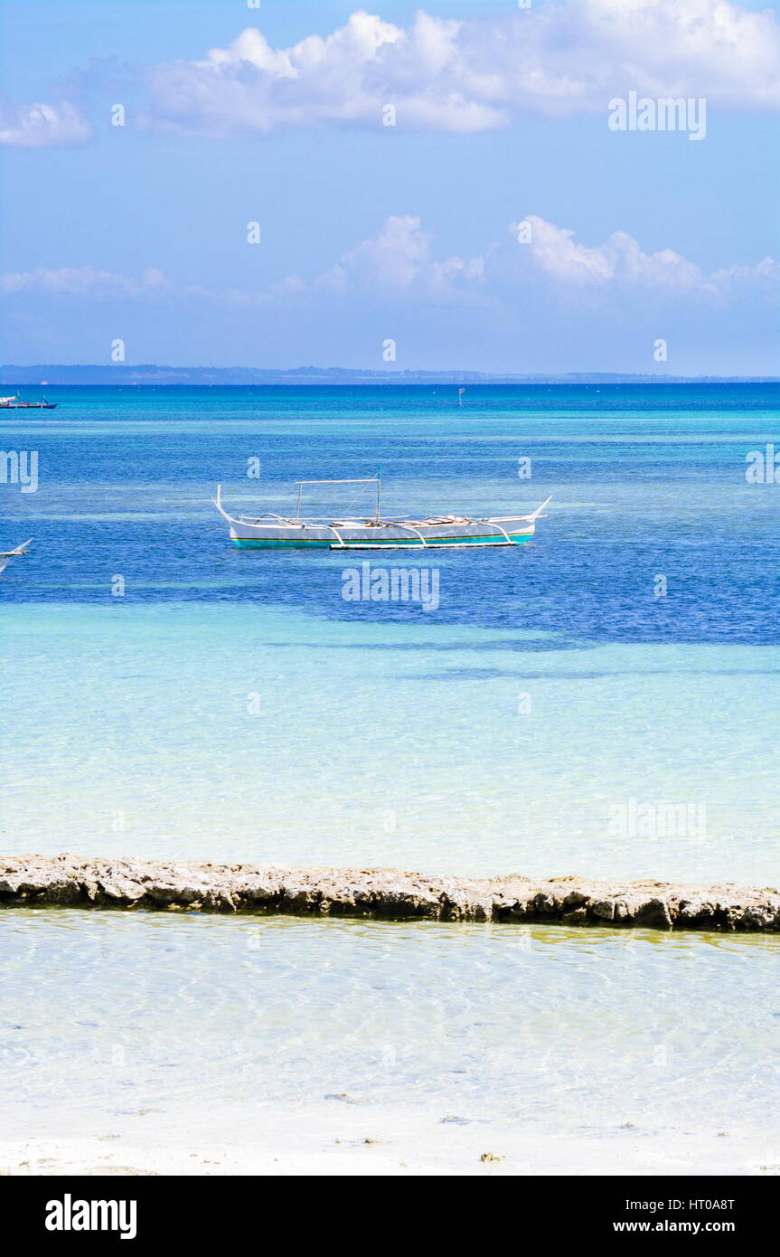 Fishing boat in the shallow blue water Stock Photo - Alamy