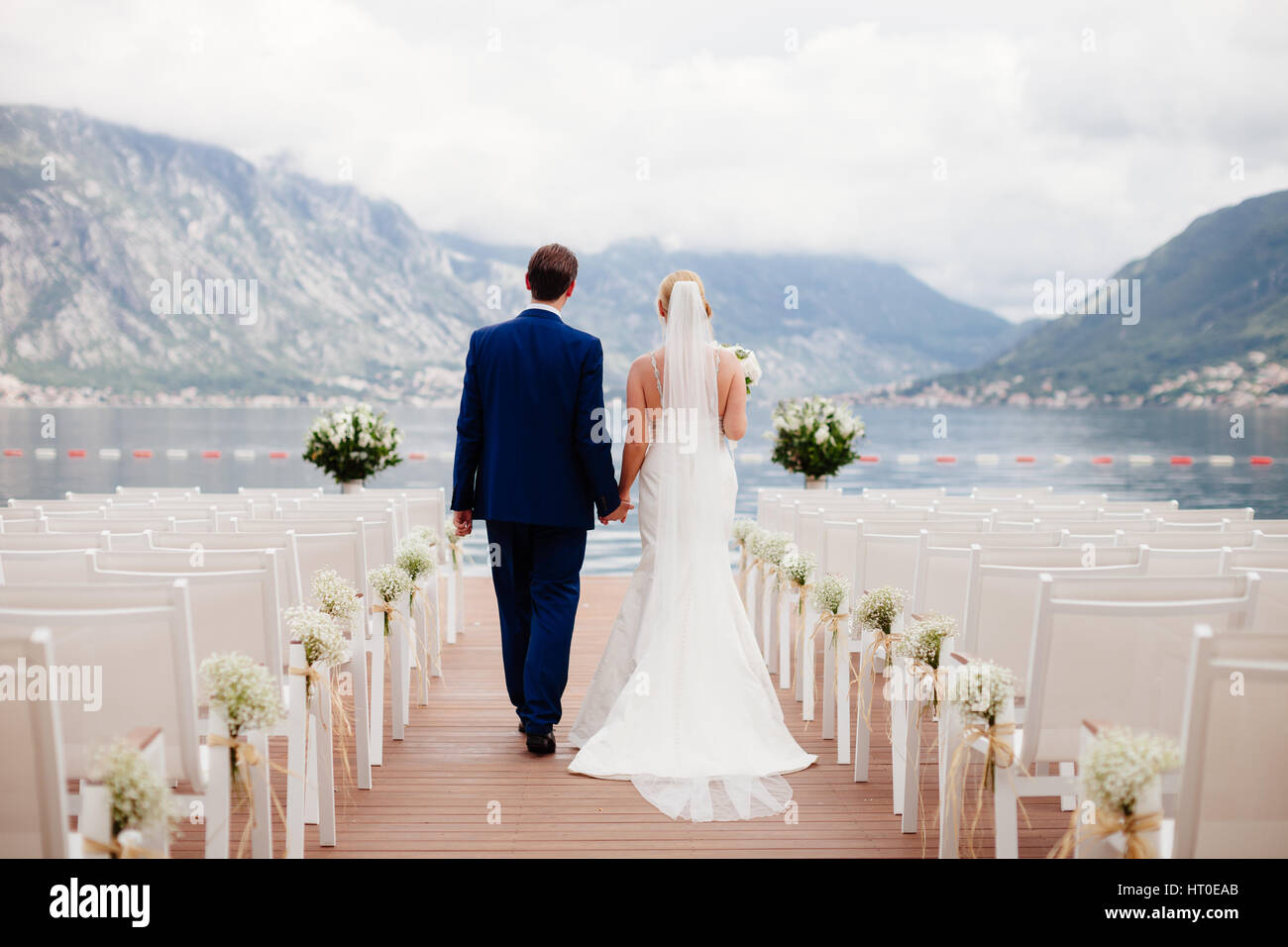 wedding couple at wedding ceremony back view. Mountains and sea ...