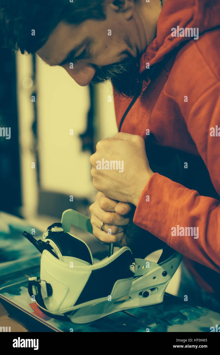 Snowboard repair shop worker adjust the bindings and equipment. Winter ...