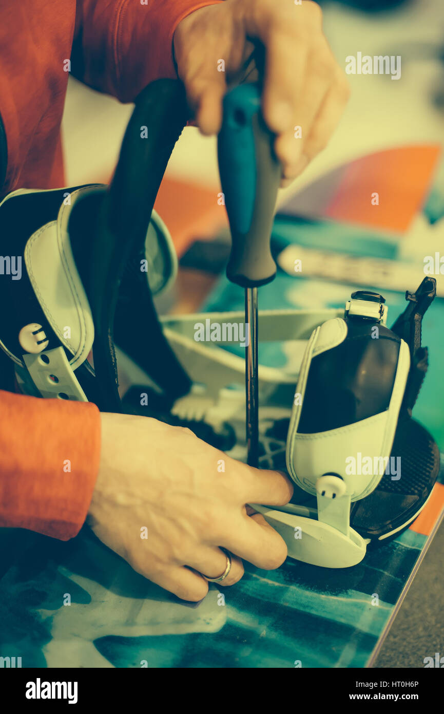 Snowboard repair shop worker adjust the bindings and equipment. Winter ...