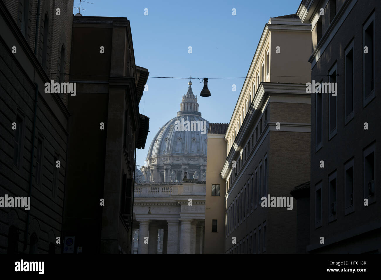 Saint Peter's dome in Rome seen through a typical roman alley Stock ...
