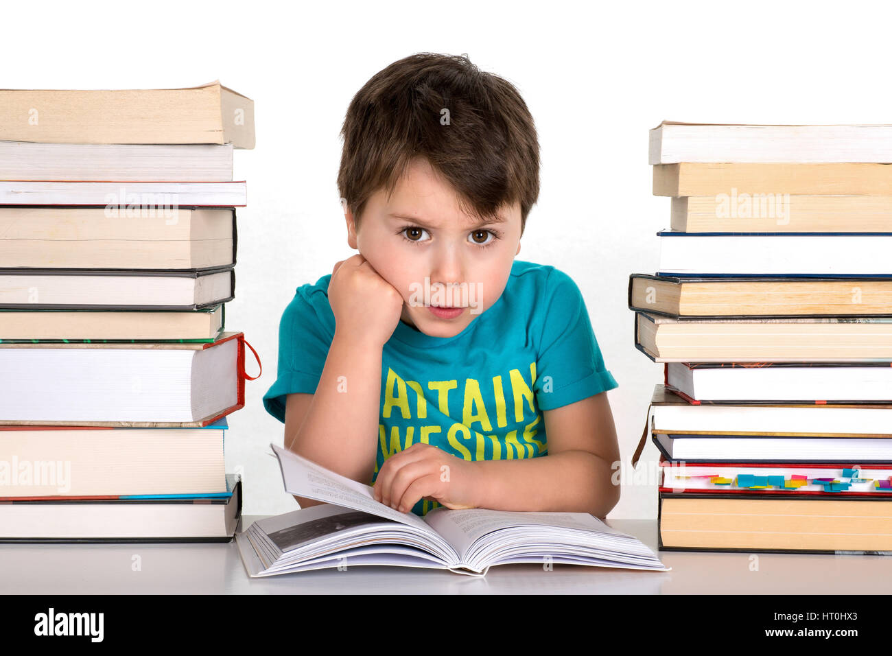 School boy reading surrounded by stack of books. Isolated on a white ...