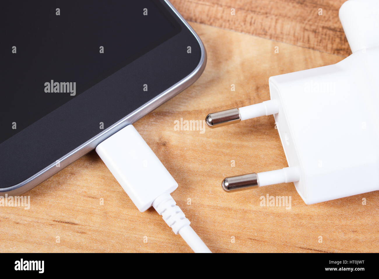 Mobile phone with connected plug of charger, smartphone charging on ...