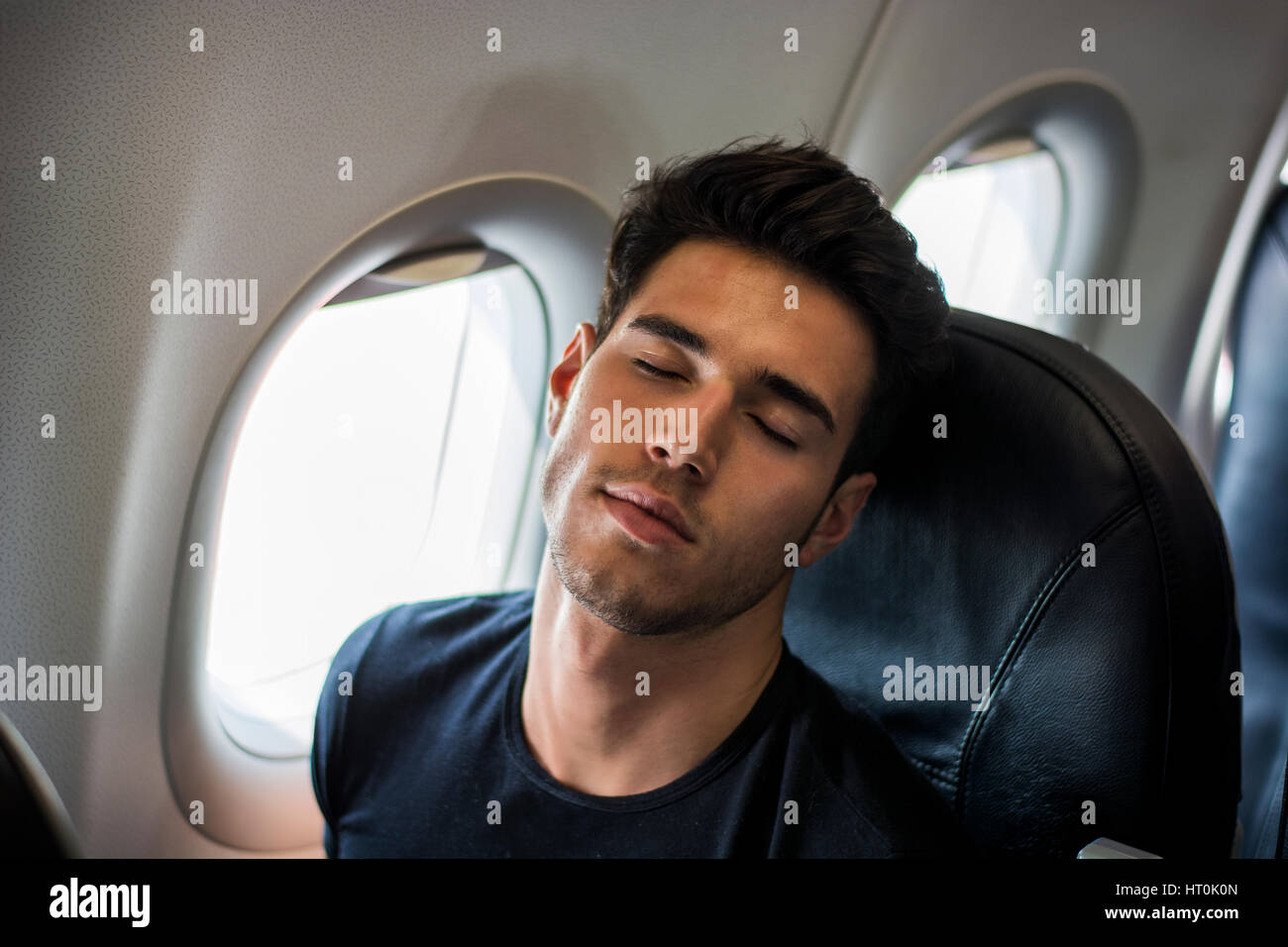 Young man in plane Stock Photo - Alamy