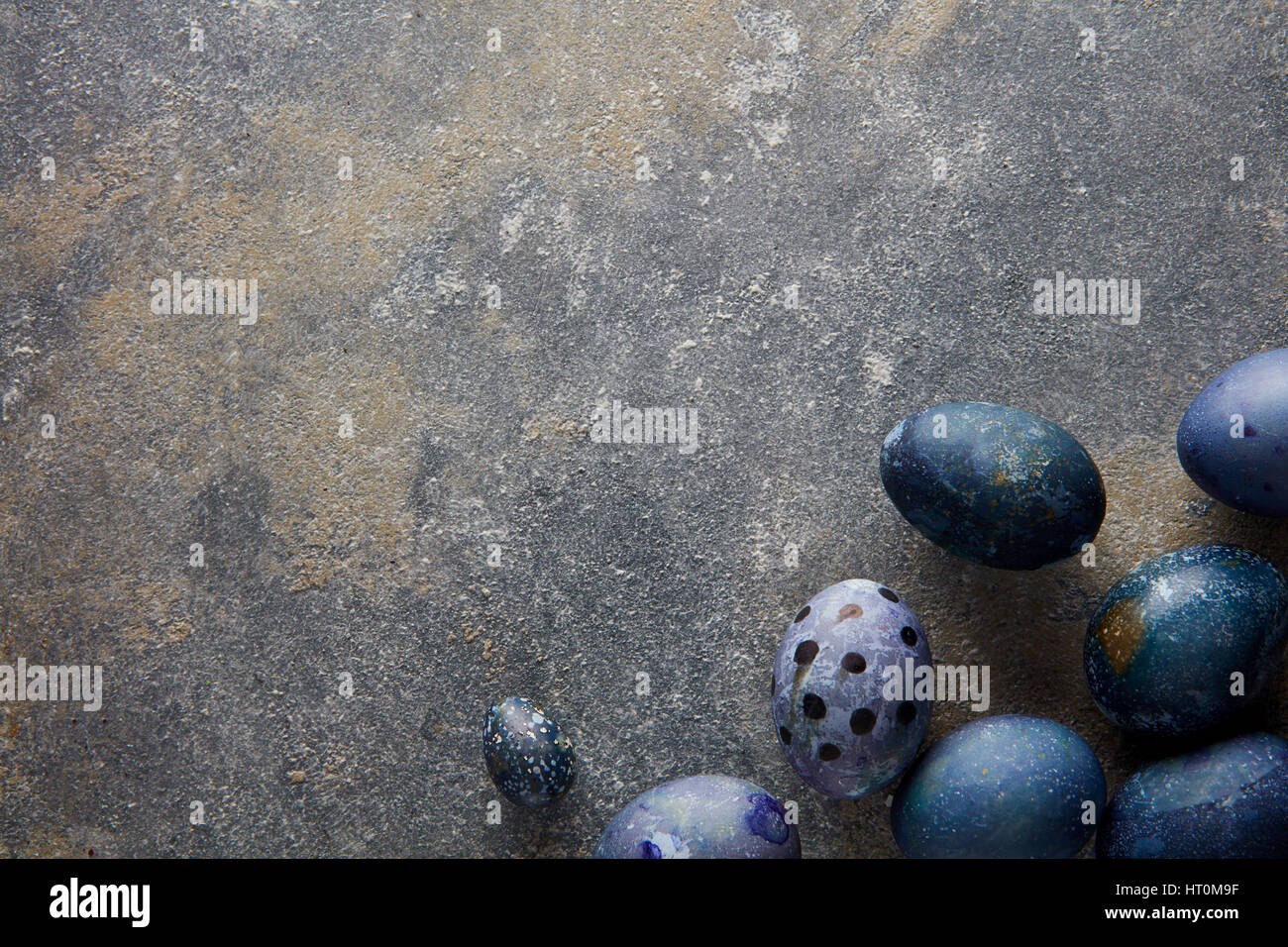 blue easter eggs in a corner of the dark concrete background, space for ...