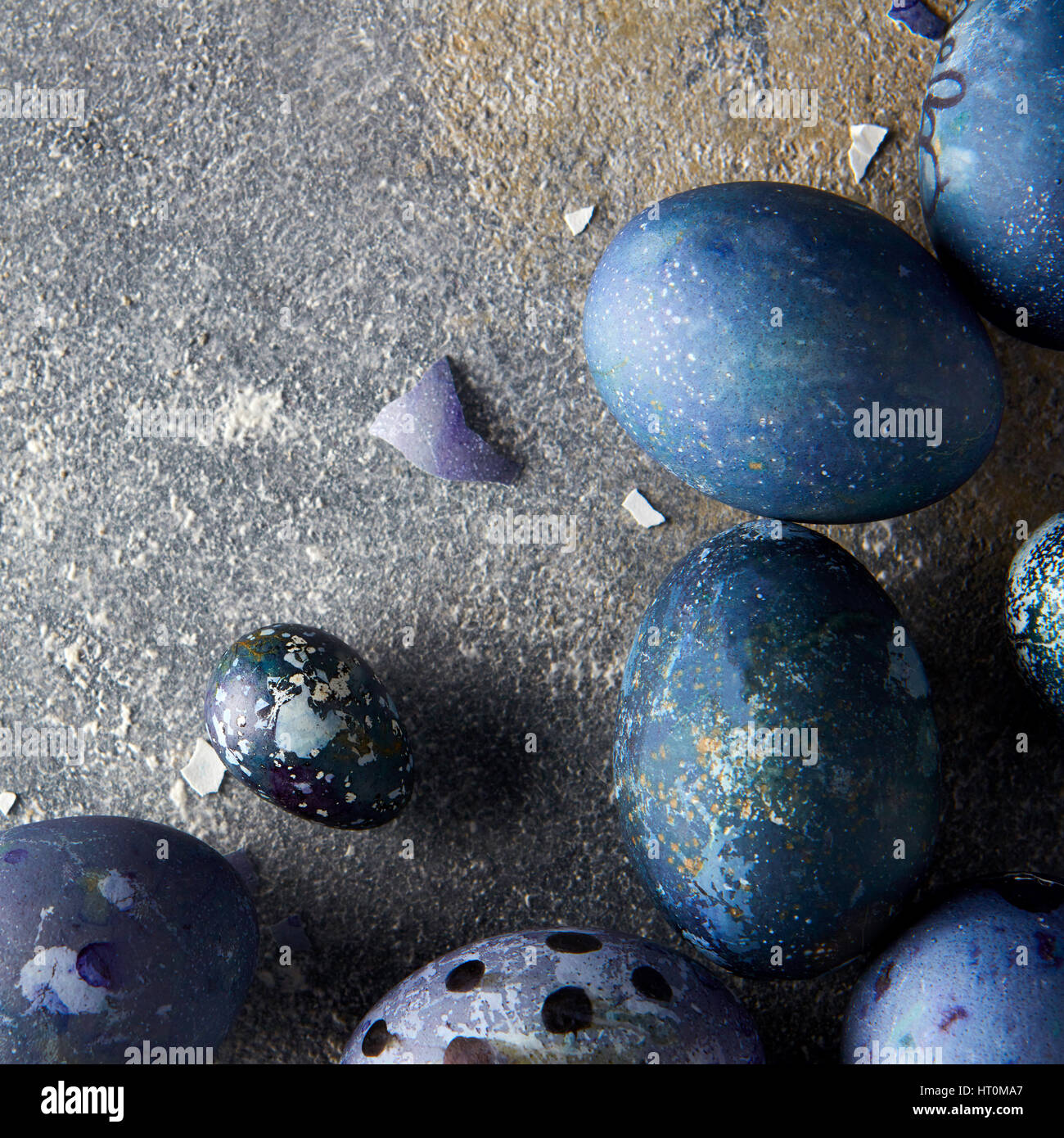 painted quail and chicken eggs on the concrete a dark background, flat ...