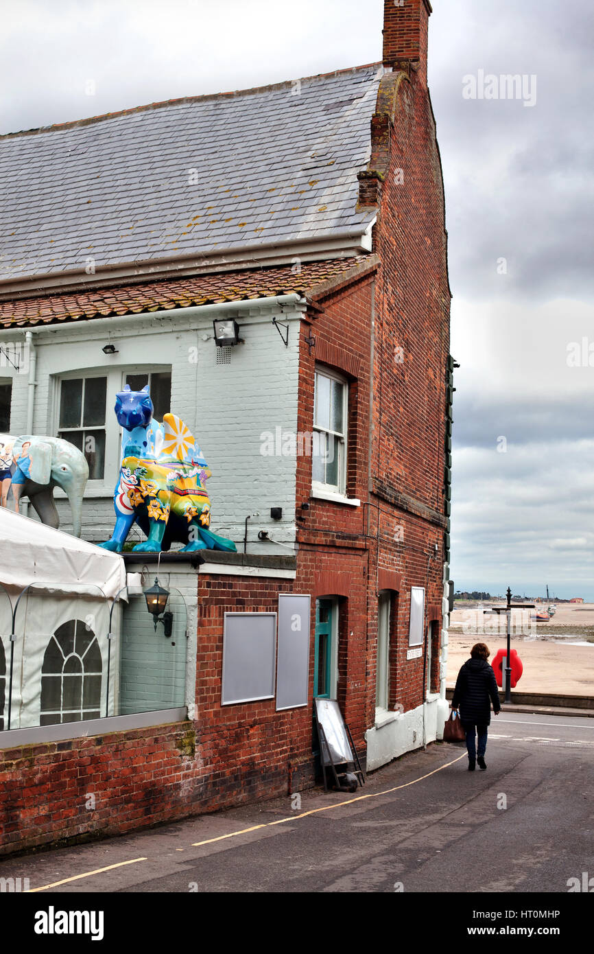 Woman walking along quiet street on a grey windy day, Wells-next-the ...