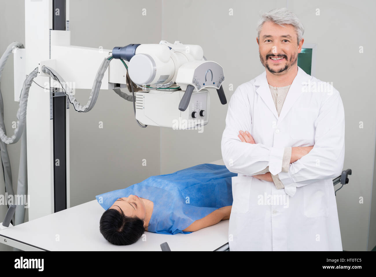 Portrait of confident male radiologist standing by female patient ...