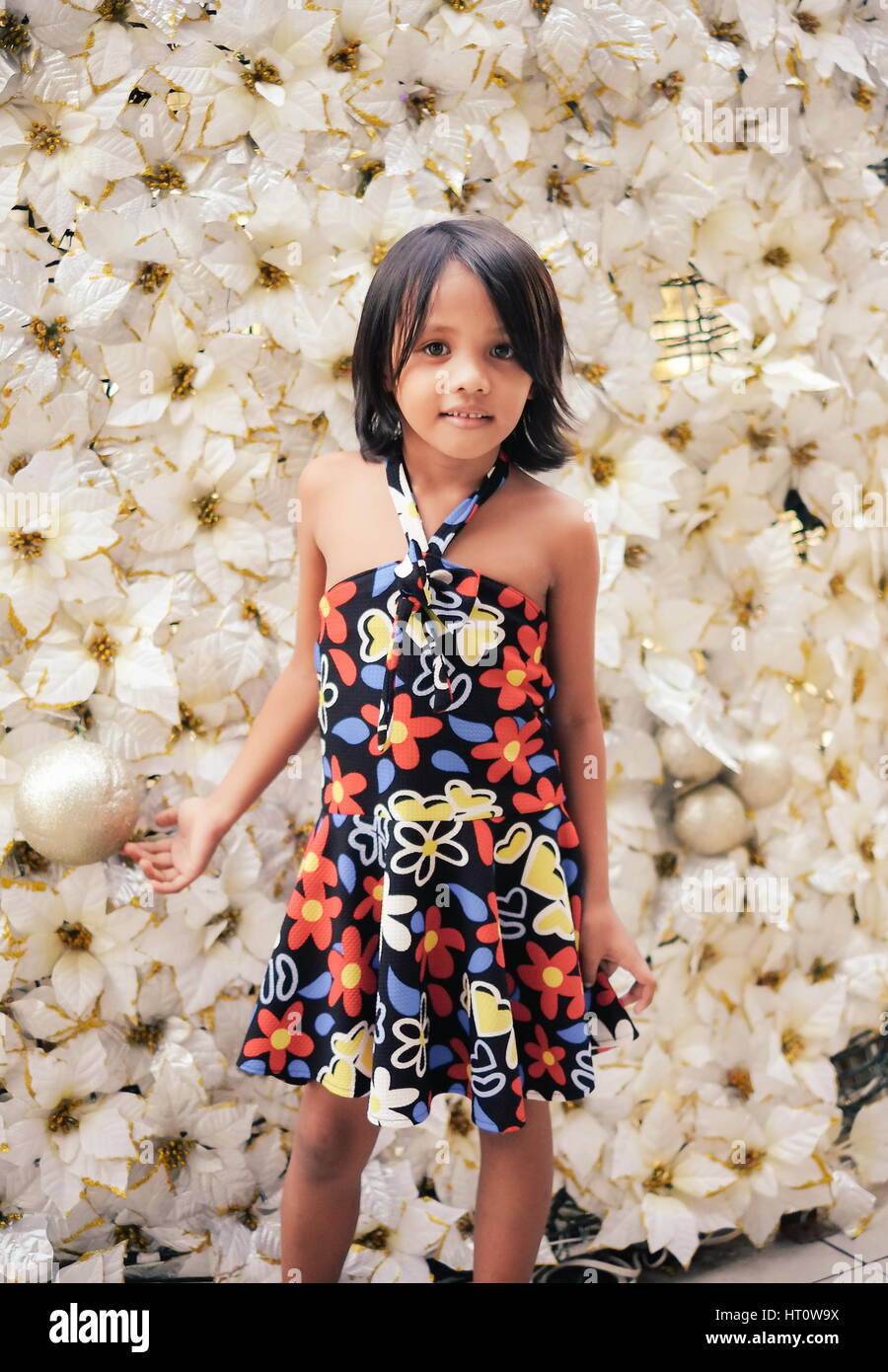 Beautiful little girl standing right near the white giant christmas ...