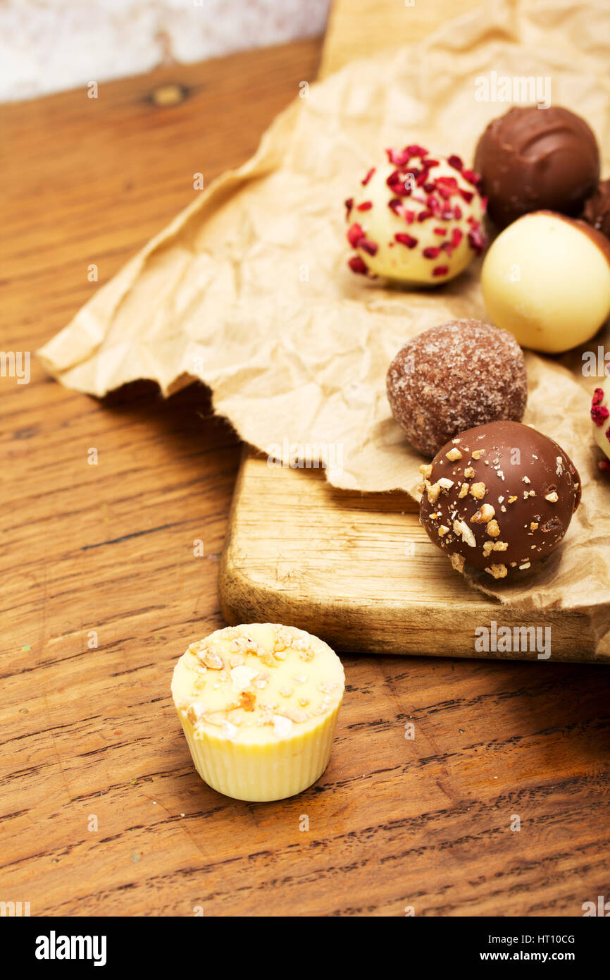 Selection of delicious chocolates on rustic background Stock Photo - Alamy