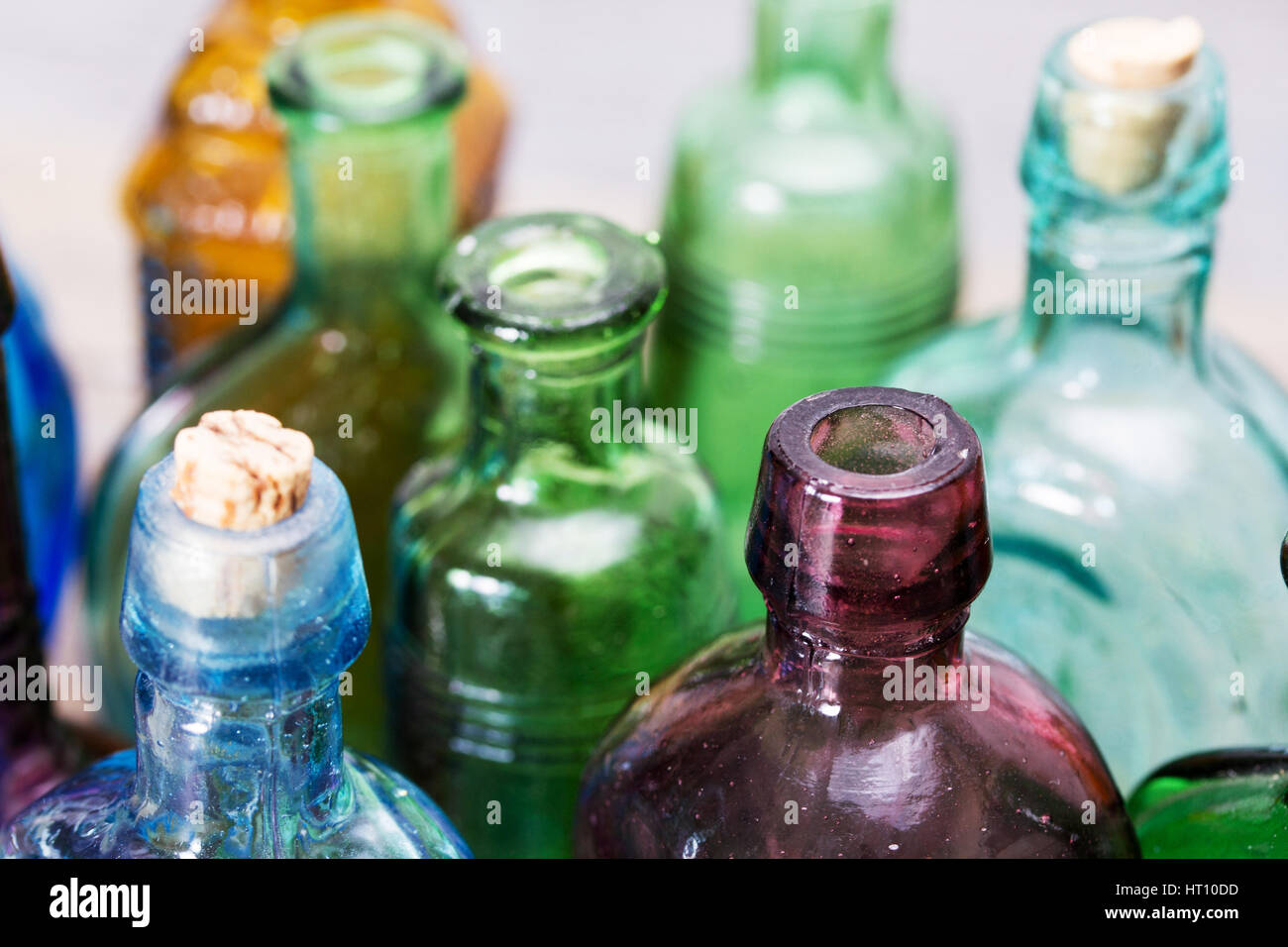Selection of coloured glass bottles on a rustic background Stock Photo ...