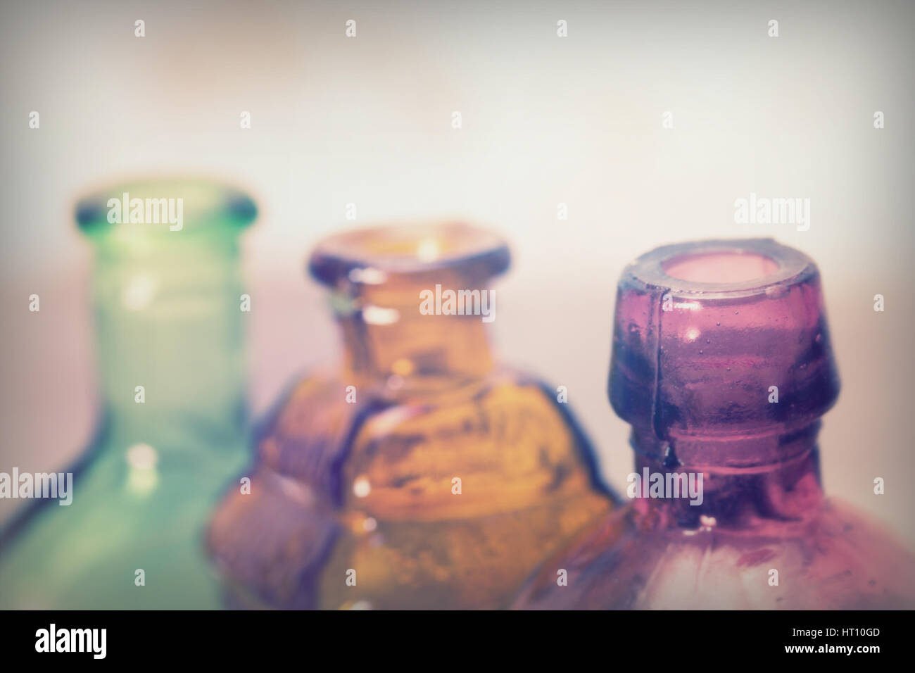 Selection of coloured glass bottles on a rustic background Stock Photo ...