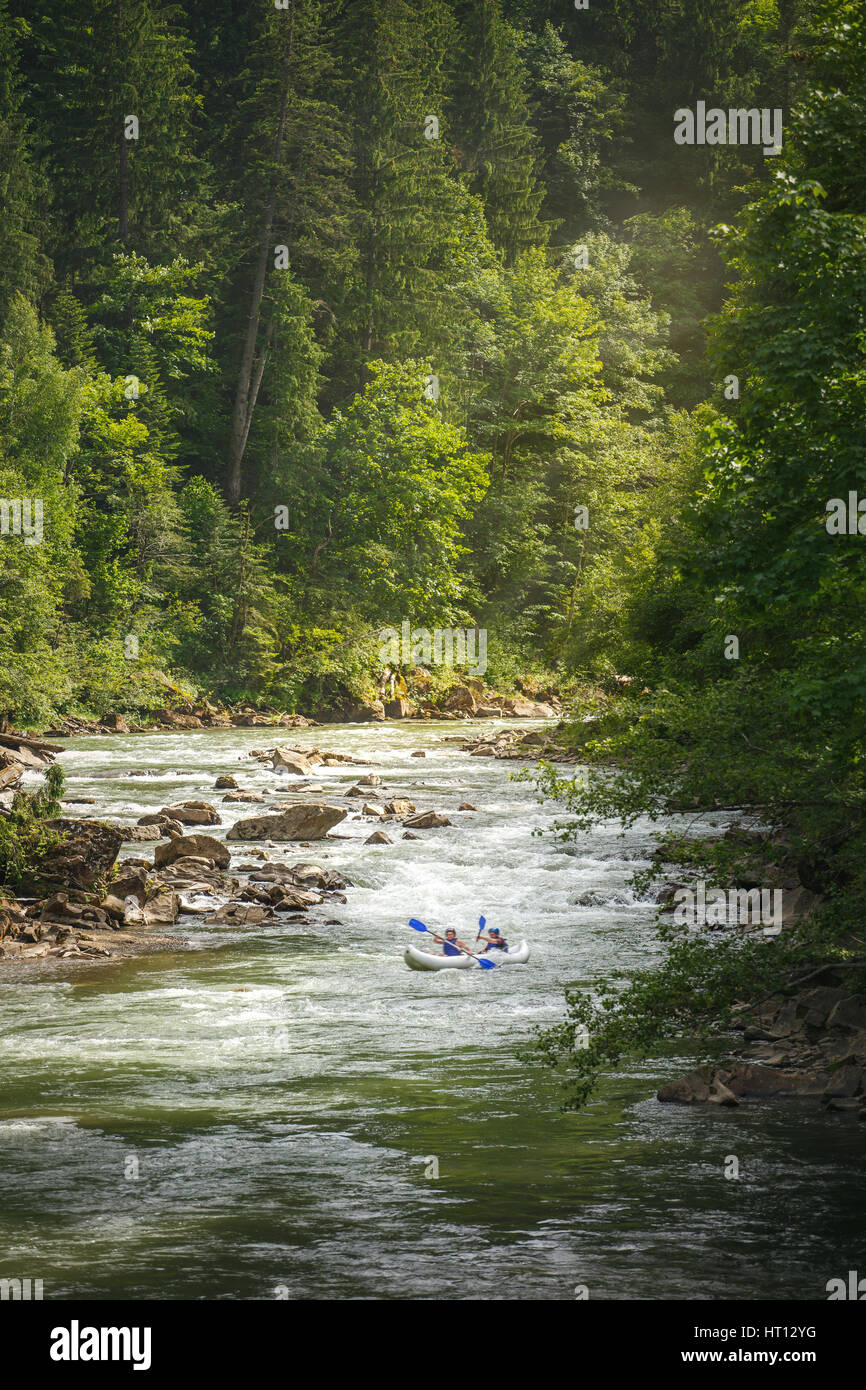 Rafting extreme sports. Two men drifting boat swift mountain river ...