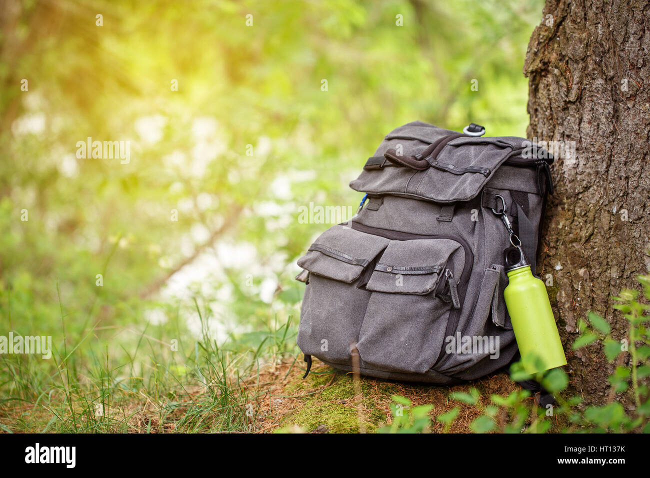 Trekking heavy backpack in forest with green jars of water. Place for ...
