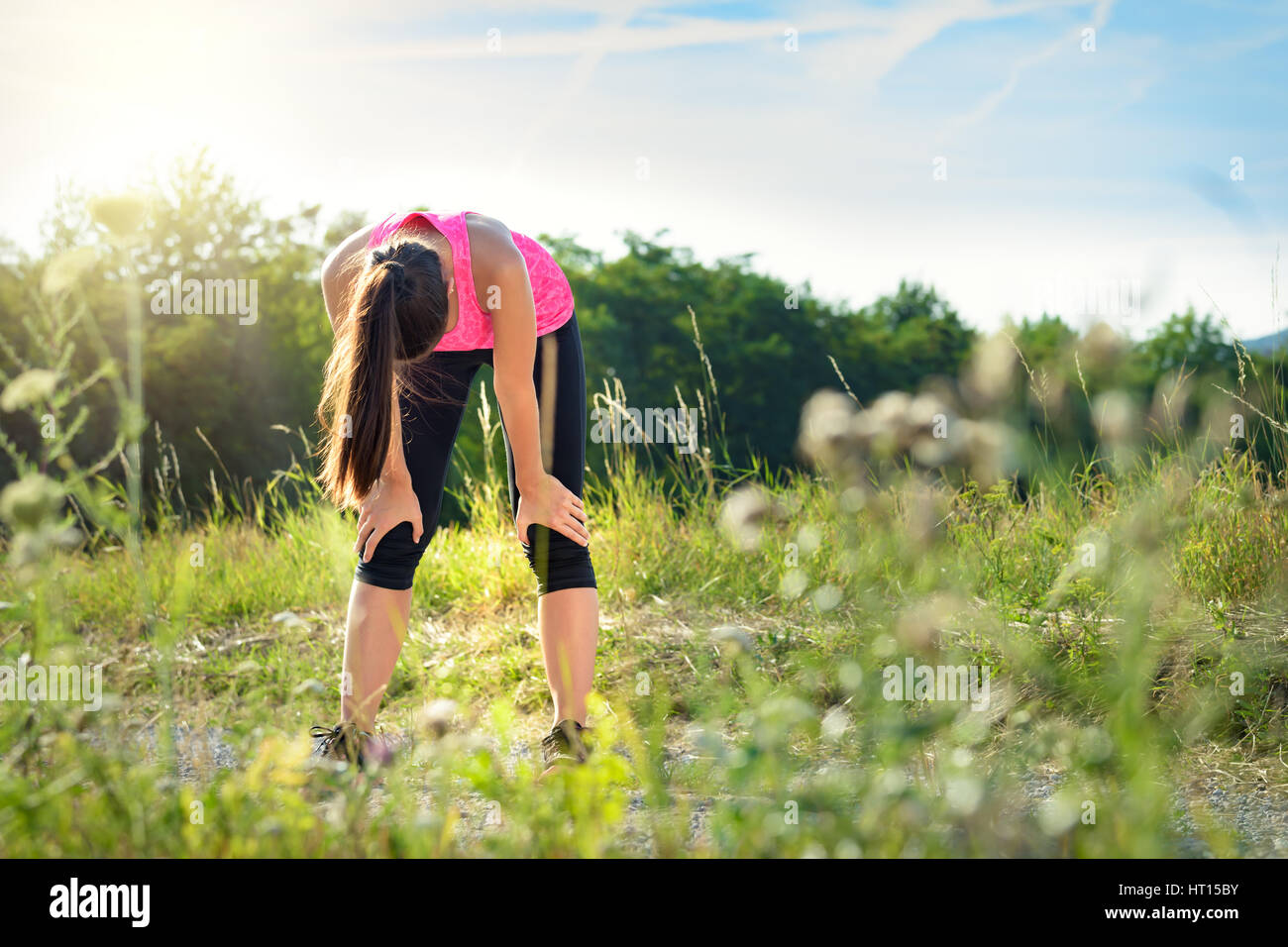 Exhausted female runner catching her breath Stock Photo - Alamy