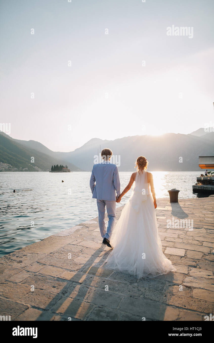 honeymoon wedding couple travel sea side. Back view. Mountains and sea ...