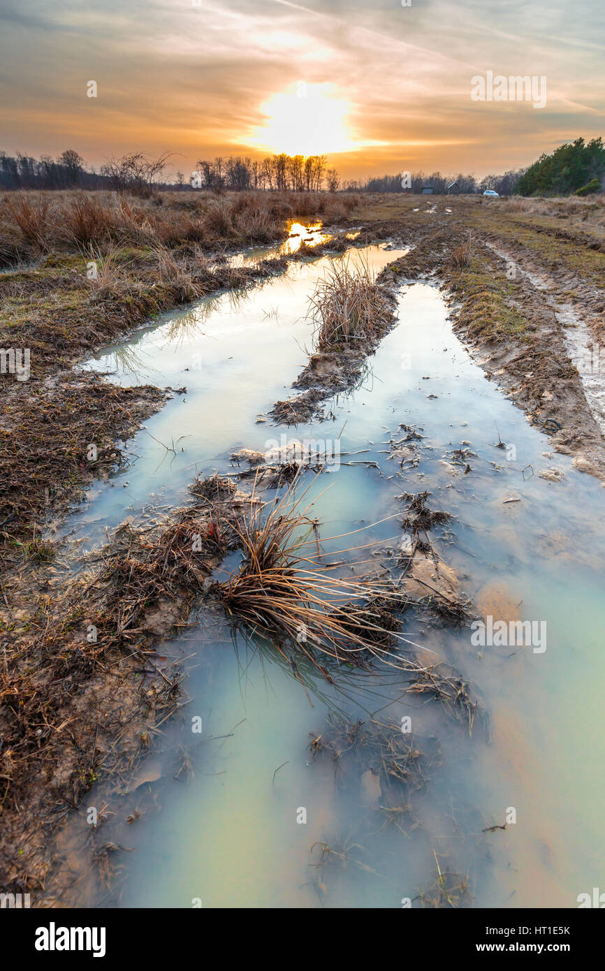 Agricultural soil with tyre tracks soaked after rain in the spring ...