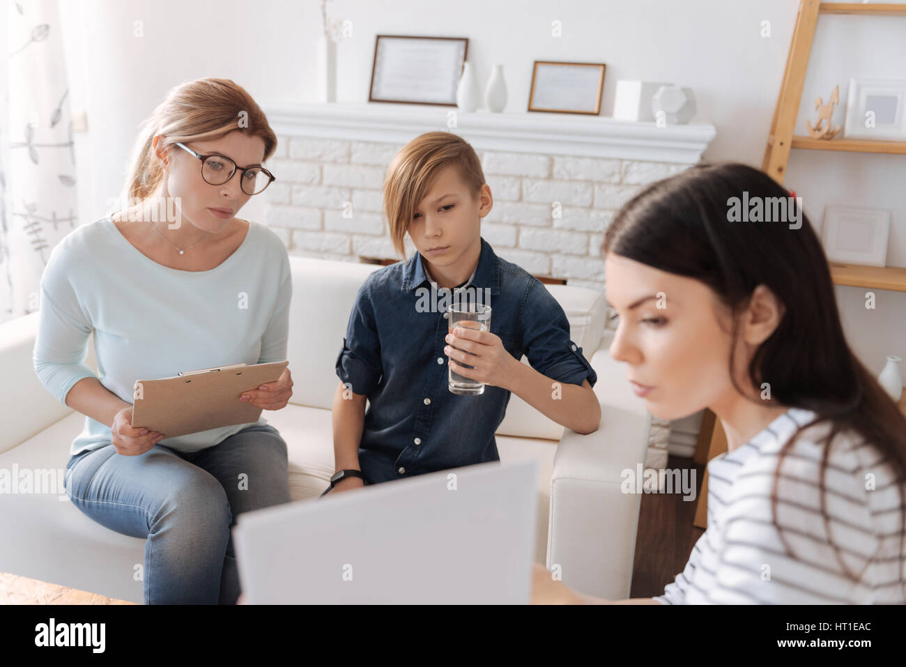 Have a look. Very attentive boy wearing jeans costume holding glass of ...