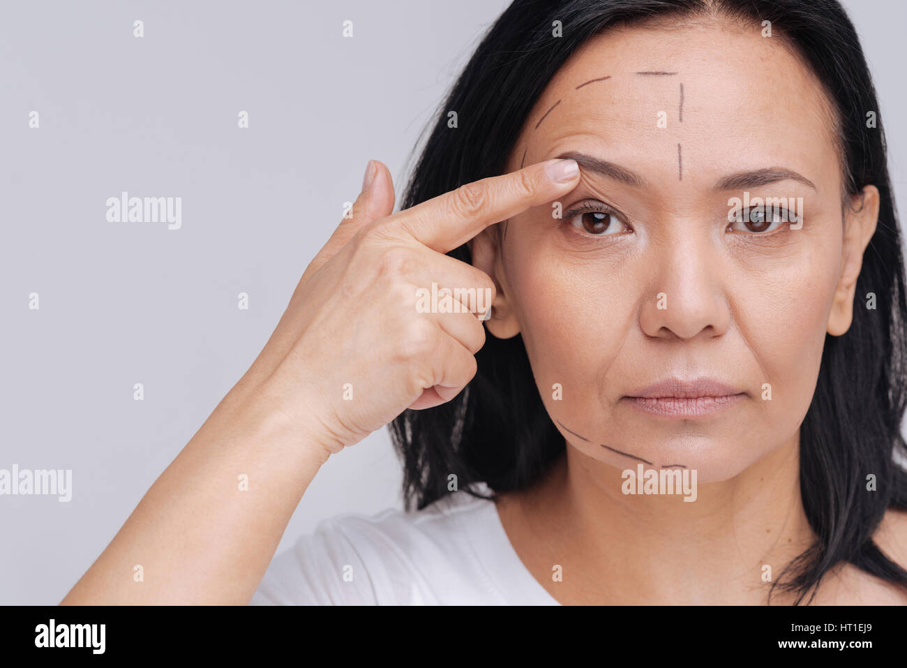 Making it better or not. Stunning young pretty lady looking unhappy ...