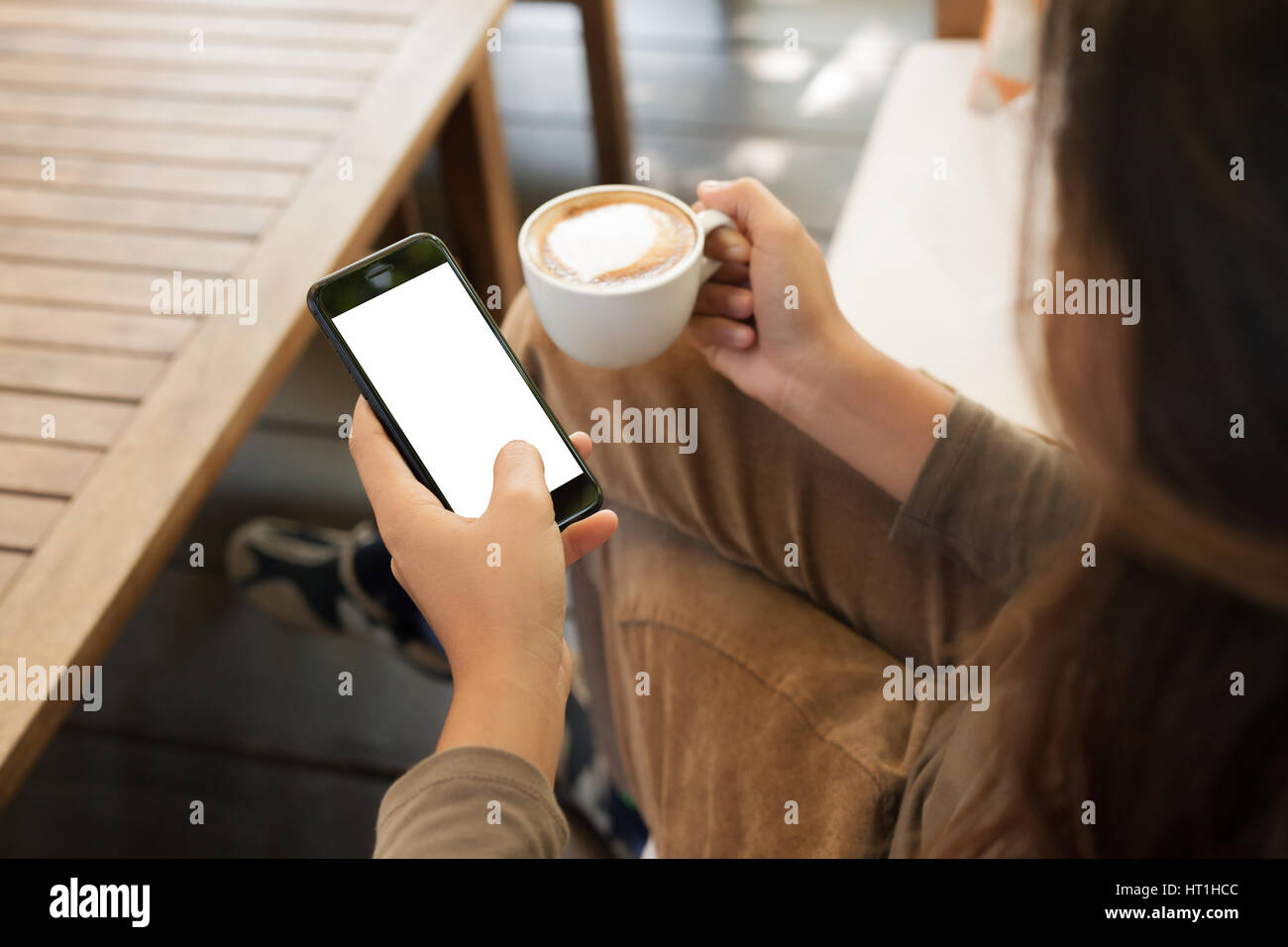 woman holding phone and coffee in cafe Stock Photo - Alamy